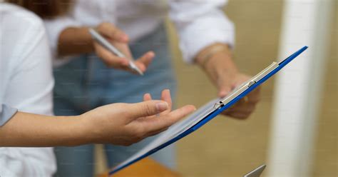 여성 관리자는 재무 보고서의 실수를 조수에게 보여주고 설명하고 손을 닫고 배경을 흐리게 합니다 사진 Unsplash의 기술 이미지