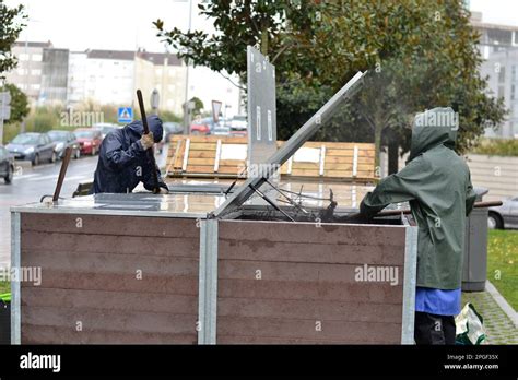 A Worker Is Managing A Community Composter Under The Rain The Composter Is Placed In A Common