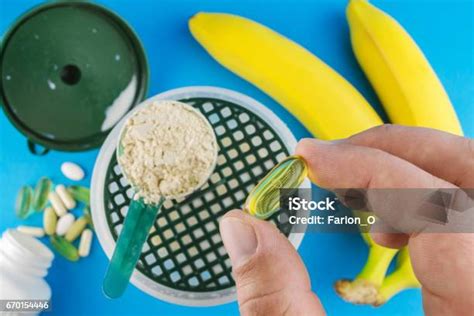 남성 손 보유 측정 스푼에 단백질 파우더 우유 파란색 배경 스포츠 영양 평면도에 두 바나나 통 병 위에 직접 오메가3 캡슐 0명에 대한 스톡 사진 및 기타 이미지 Istock