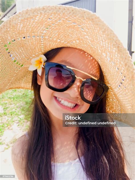 긴 검은 머리 여자는 웃 고 검은 선글라스 밀 짚 모자와 오른쪽 귀 뒤에 흰 꽃을 입고 8 9 살에 대한 스톡 사진 및 기타 이미지 8 9 살 검정 머리 관광