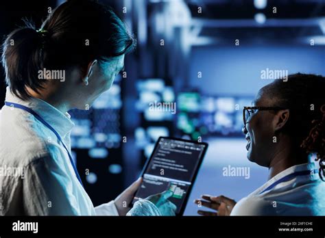 Engineer And African American Colleague Building Firewall Systems In Server Room Man And Woman