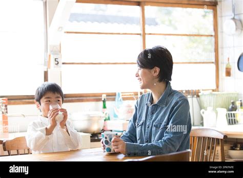Boy Drinking Milk With His Mother Stock Photo Alamy