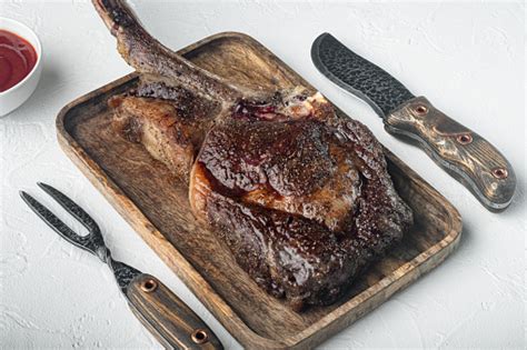 향신료와 함께 구운 토마호크 쇠고기 스테이크 나무 서빙 보드에 흰색 돌 배경 꽃등심 스테이크에 대한 스톡 사진 및 기타 이미지 꽃등심 스테이크 흰색 배경 뼈 Istock