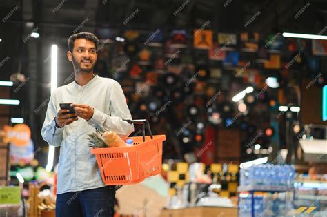 Premium Photo Young Man Using Mobile Phone While Shopping At Supermarket
