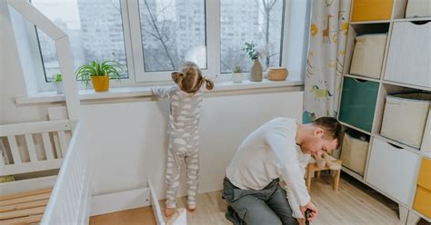 어린 4 살 소녀는 아버지가 어린이 침실에서 침대 서랍을 조립하거나 고정하는 것을 돕습니다 사진 Unsplash의