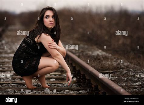 Young Woman With Long Hair Crouching On A Railway Track Croatia Stock