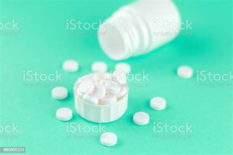 알 약과 캡슐 아쿠아 마린 배경 복사 공간에 모자에 밖으로 유출 흰색 알 약 병을 닫습니다 전경 부드러운 Bokeh에 초점 약국 약국 개념 0명에 대한 스톡 사진 및 기타