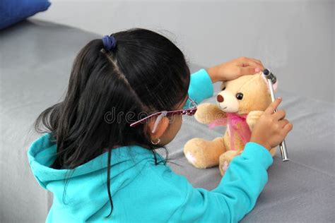 Little 4 Year Old Latina Girl Examines Her Sick Teddy Bear Imitates
