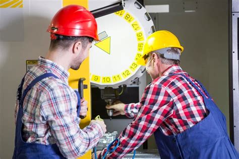 Premium Photo Two Men In Factory Working At Cnc Machine