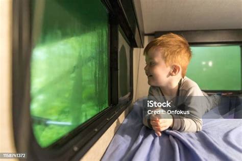 비가 오는 동안 캠퍼 트레일러에서 창 밖을 바라보는 작은 빨간 머리 소년 창문에 대한 스톡 사진 및 기타 이미지 창문 여행용 트레일러 젖은 Istock
