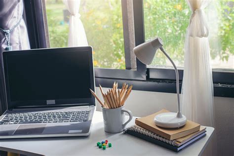 학생 교육 개념을위한 책상 데스크톱 노트북 연필 책 메모장 램프 및 핀은 집에서 온라인으로 학생 작업을 위해 학교 테이블에 배치됩니다 책상에 대한 스톡 사진 및 기타 이미지