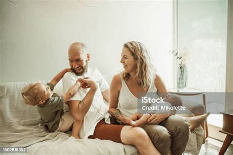 부모 자녀 그리고 가족과 함께 집 거실의 소파에 앉아 유대감을 형성합니다 어머니 아버지 아이들이 귀여운 아기와 장난기 많은