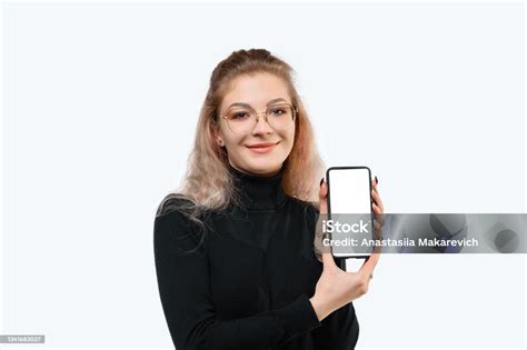흰색 배경에 서 광고를 표시하는 빈 스마트 폰 화면을 보여주는 미소 젊은 여자 20 24세에 대한 스톡 사진 및 기타 이미지