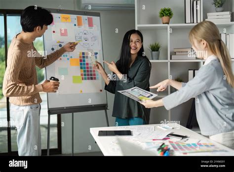 Creative Team Collaborating On Ux Ui Design Project In Modern Office Environment With Whiteboard