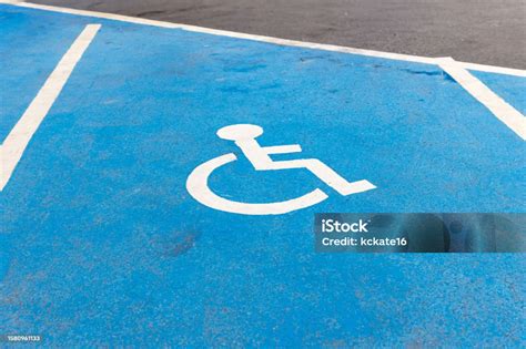 장애인 또는 휠체어 주차 표지판은 주차장에 장애인을위한 예약 주차를 나타냅니다 쇼핑 센터 주차 공간에 밝은 파란색으로 그려진 국제 장애인 기호 도시에 대한 스톡 사진 및