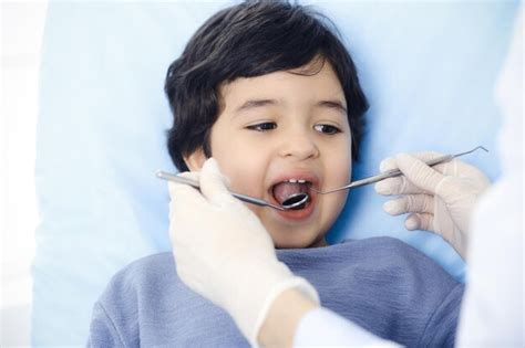 Lindo Niño árabe Sentado En El Sillón Dental Con La Boca Abierta