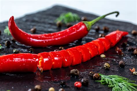 신선한 칠리 페 퍼는 향신료와 검은 돌 배경에 허브와 매운 요리 요리의 개념 요리의 재료 위쪽에서 보기입니다 플랫 리 0명에