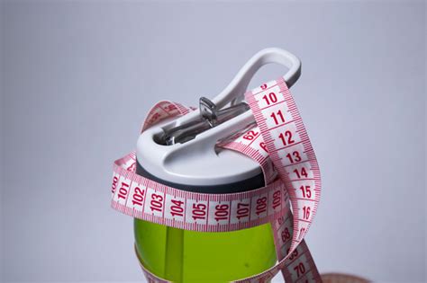 녹색 스포츠 병 위에 빨간색 측정 테이프 건강한 삶 스포츠 컨셉 맨 위 보기입니다 공간을 복사합니다 격리 흰색 배경 가냘픈에