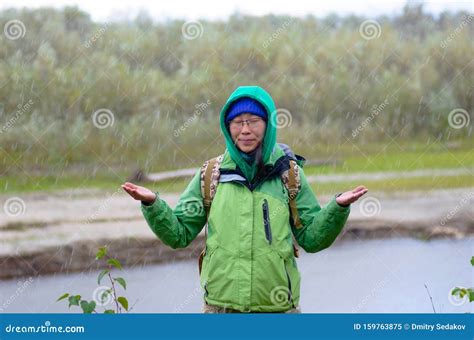 Yakut Asian Girl Tourist In A Jacket Hat And Hood And With A Backpack