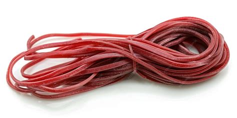 A Long Red String Of Candy Is Laying On A White Background Premium Ai