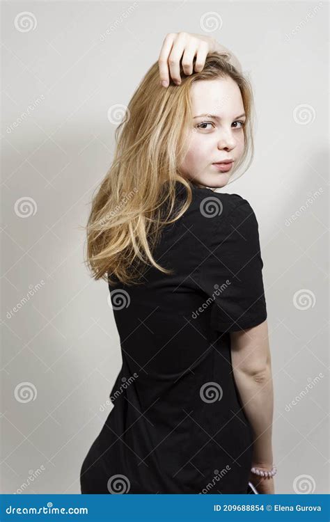 La Chica Se Queda Media Vuelta Y Toca El Pelo Con La Mano Foto De Archivo Imagen De Femenino