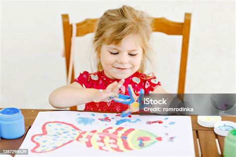 작은 창조적 인 유아 소녀는 물고기를 색칠 손가락으로 그림 활동적인 아이는 집에서 유치원에서 그리기와 재미를 아이들을위한 교육