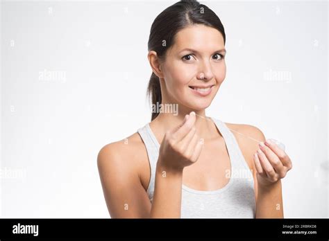 Woman Flossing Her Teeth With Dental Floss To Remove Any Food Particles