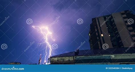 Lightning Illuminating Urban Skyline At Night During Thunderstorm With