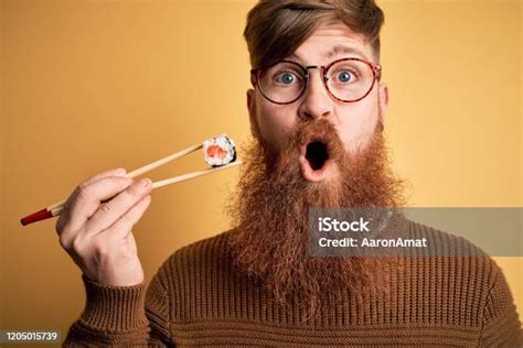 Redhead Irish Man With Beard Eating Salmon Maki Sushi Using Chopsticks