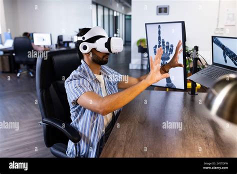 Using Vr Headset Indian Man Interacting With Robotic Hand Simulation In Modern Office Stock