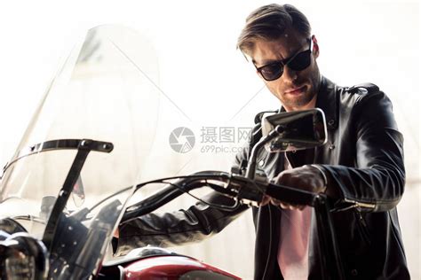 穿着太阳眼镜和皮夹克的帅气英俊年轻男子坐在摩托车上高清图片下载 正版图片502629743 摄图网