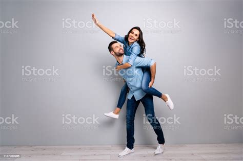 전체 길이 몸 크기 사진 펑키 응원 그녀 그녀는 그에 게 그는 그의 여자 남자 피기백 타고 산책 모험 핸드 팔 실행 주자 캐주얼 청바지 데님 셔츠 의상 옷 절연 회색 배경