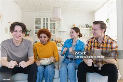 Tv에서 스포츠 경기 축구 축구 경기를 보는 친구들 집에서 승리를 축하하는 행복한 축구 팬들 우정 스포츠 엔터테인먼트 개념입니다 다양한 친구들이 집에서 함께 즐거운 시간을