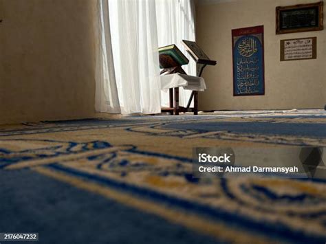 나무 스탠드에 열린 꾸란과 이슬람 벽 예술이 있는 기도실 내부는 커튼을 통해 들어오는 햇빛과 함께 신앙과 헌신의 테마에 적합합니다 브루나이에 대한 스톡 사진 및 기타 이미지