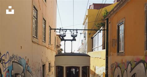 建物の隣の線路を走る黄色と白の列車の写真 Unsplashの建物の無料画像