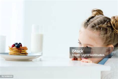 작은 아이 보고 수 제 팬케이크 딸기 꿀 그리고 테이블에 우유의 유리의 선택적 초점 가정 생활에 대한 스톡 사진 및 기타 이미지