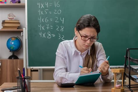 Free Photo Young Woman Teacher Wearing Glasses Writing Something In