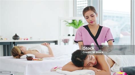 아시아 여성 안마사는 스파 살롱에서 여성 고객의 등을 마사지하는 허브 핫볼 테라피를 사용합니다 테라피 타이 마사지 바디 케어 컨셉 2명에 대한 스톡 사진 및 기타 이미지