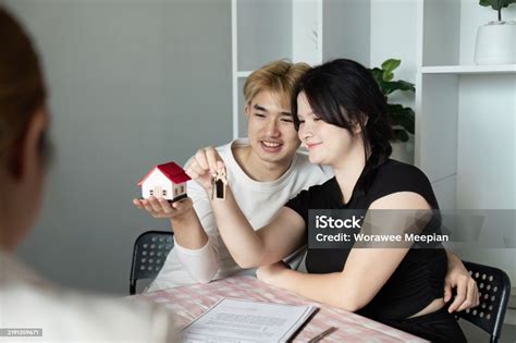 집 모델과 열쇠를 들고 부동산 사무실 환경에서 새 주택 구입을 축하하는 행복한 커플 계약서에 대한 스톡 사진 및 기타 이미지 계약서 계획 구매 Istock