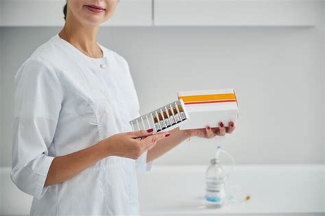 Premium Photo A Woman In A Lab Coat Holding An Open Carton Box Of