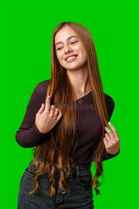 Smiling Woman With Long Brown Hair Adjusting Her Clothes In Front Of A