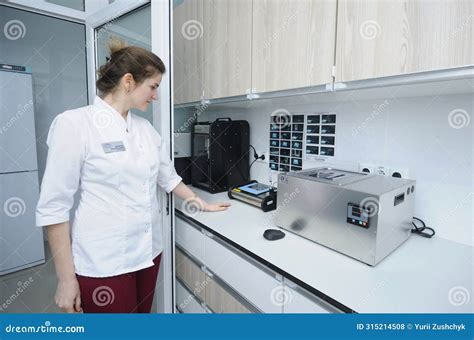 At The Human Milk Bank Laboratory Lab Assistant Standing Near Table With Milk Heating Box