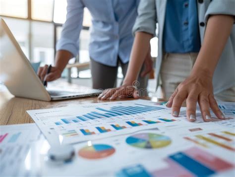 Business Teamwork Planning And Analysis Discussion With Charts And Graphs In Office Environment