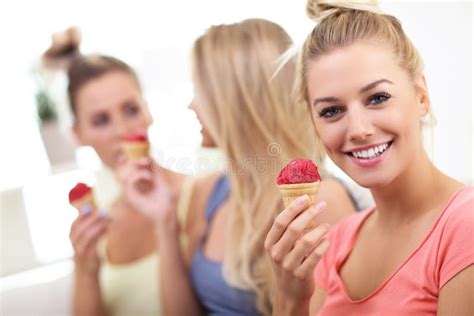Tres Mujeres Jovenes Hermosas Que Comen El Helado En Casa Imagen De