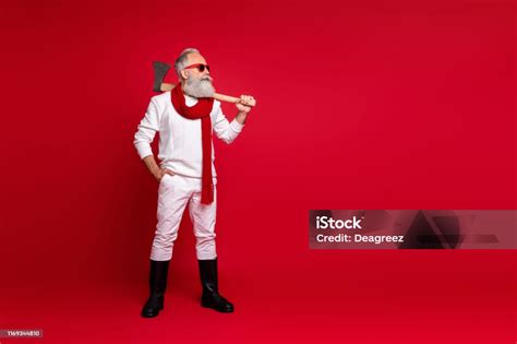 풀오버 스웨터 바지 부츠에 밝은 선명한 광택 빨간 배경에 고립 된 도끼 커터를 들고 좋은 매력적인 잘 생긴 콘텐츠 Virile 남성 회색 머리 남자의 전체 길이 바디 사이즈