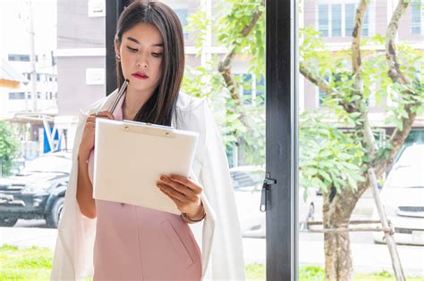 젊은 아름다운 사업가 사무실창 근처에 서 있는 보고서를 확인 비즈니스 개념n 경영자에 대한 스톡 사진 및 기타 이미지 경영자