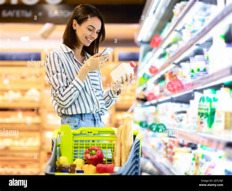 Woman Scanning Code On Products Using Smartphone Stock Photo Alamy
