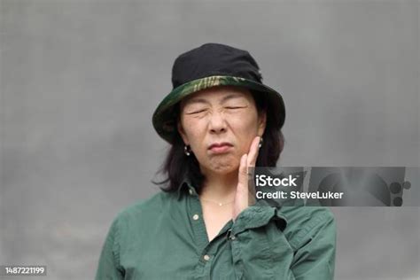 모자를 쓰고 불편한 표정으로 얼굴을 맞대고 있는 아시아 여성 45 49세에 대한 스톡 사진 및 기타 이미지 45 49세 50 54세 50 59세 Istock
