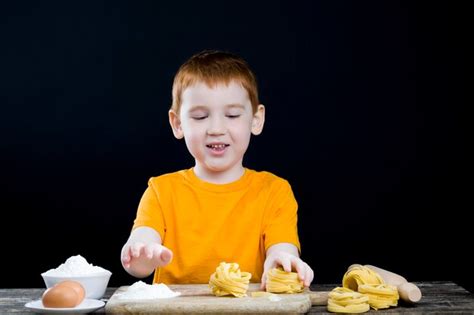 Porträt eines kleinen Jungen in der Küche der beim Zubereiten von Speisen hilft ein Junge mit