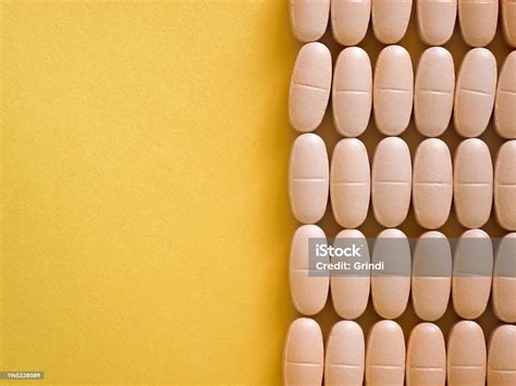 의학 약국 정제 배경입니다 약의 매크로 근접 촬영 세트와 공간 이랑 복사 노란색 및 분홍색 색조의 캡슐의 세로 오른쪽 행 라인